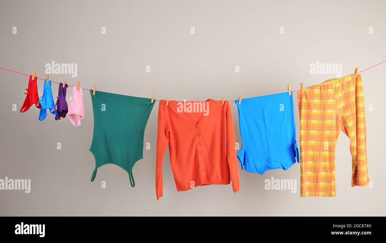 Laundry line with clothes on wall background Stock Photo - Alamy