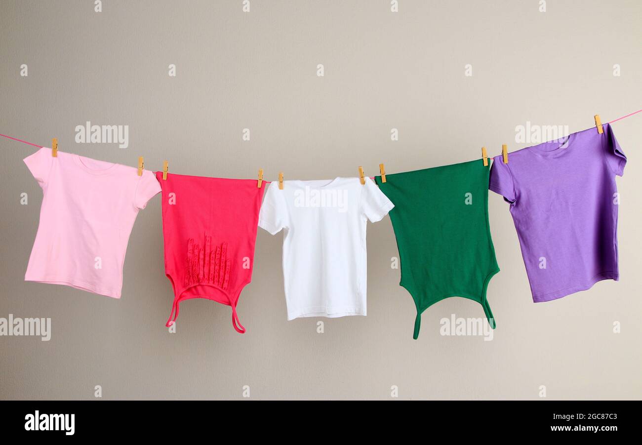 Laundry line with clothes on wall background Stock Photo - Alamy