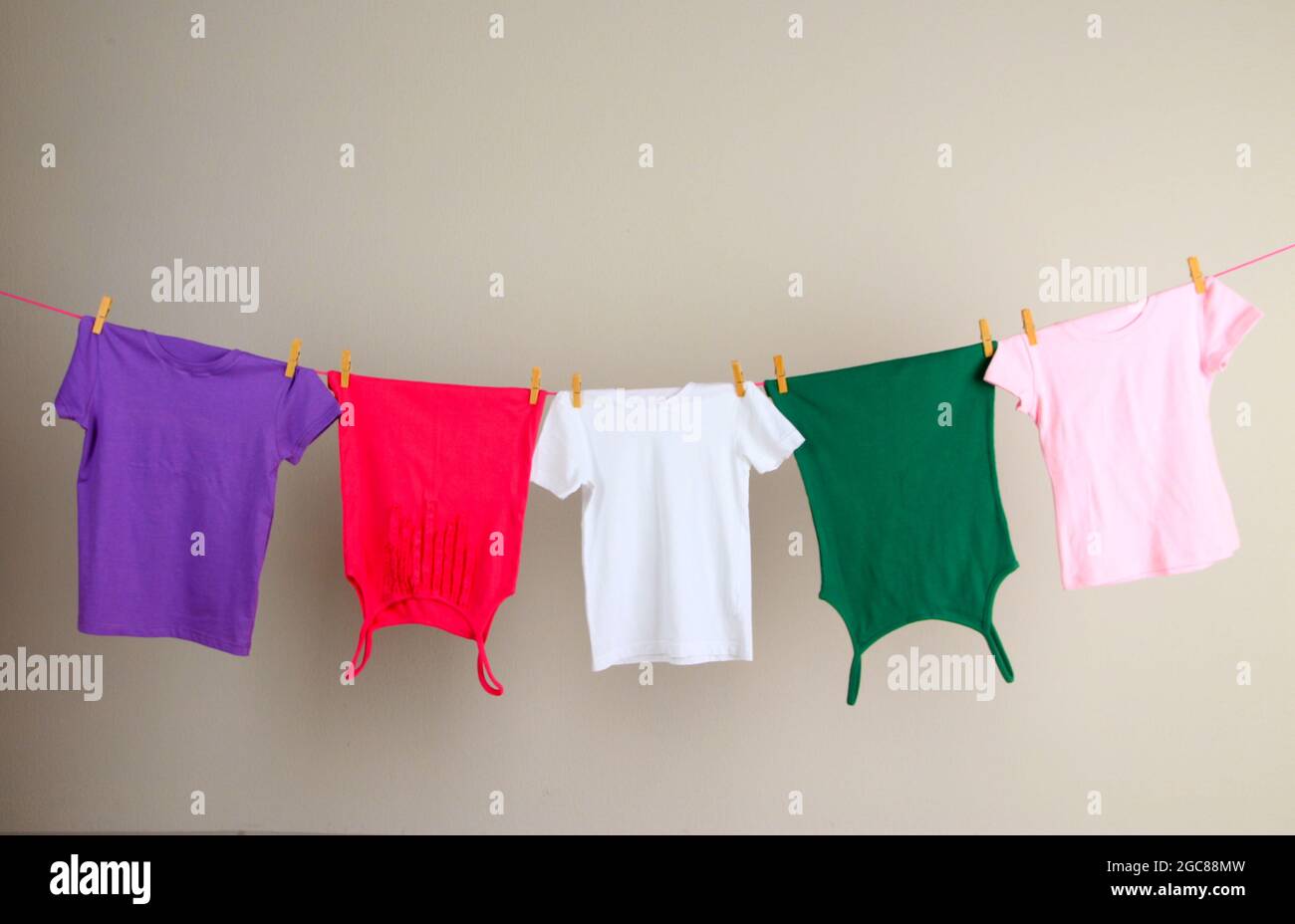 Laundry line with clothes on wall background Stock Photo - Alamy