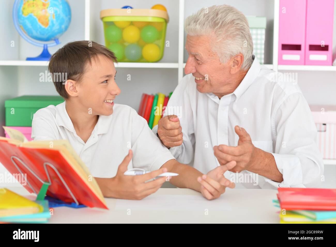 Grandfather with grandson doing homework at home Stock Photo - Alamy