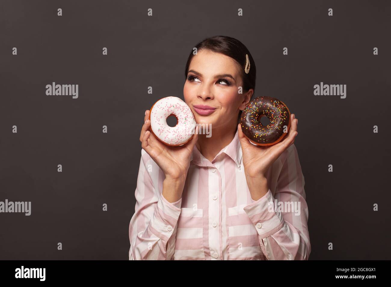 Portrait of perfect woman with donuts posing on black background ...