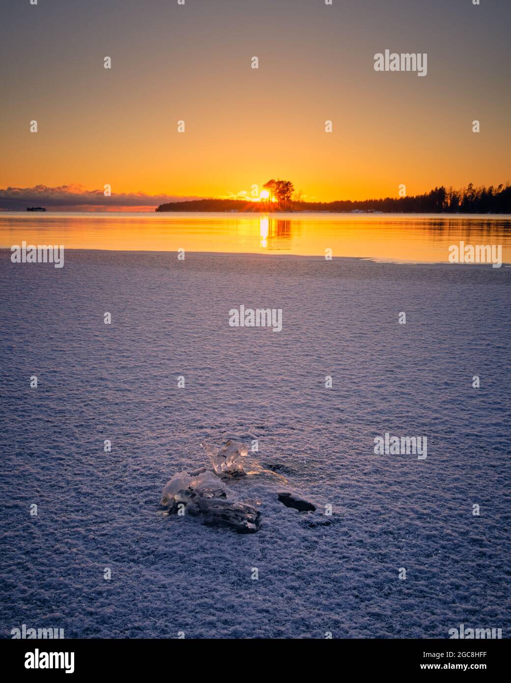 sunset over the sea and snow on the beach Stock Photo - Alamy