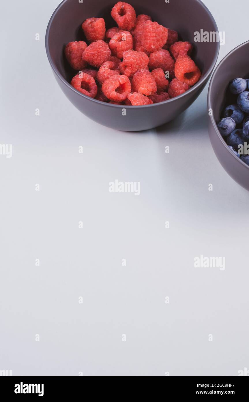 Bowls of fresh blueberries and raspberries isolated on a white ...