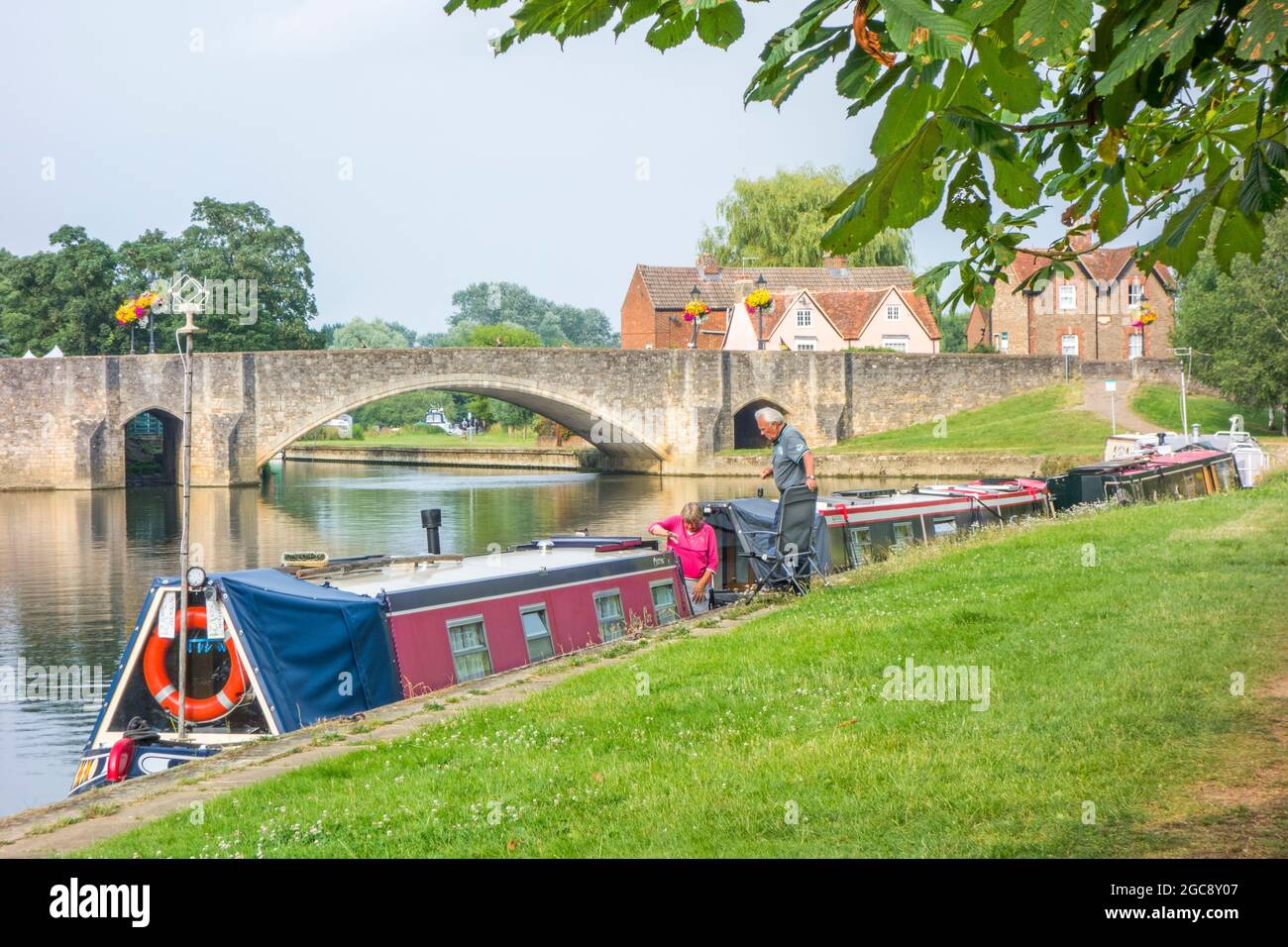 Man mooring a canal narrowboat on the river Thames at Abingdon on ...