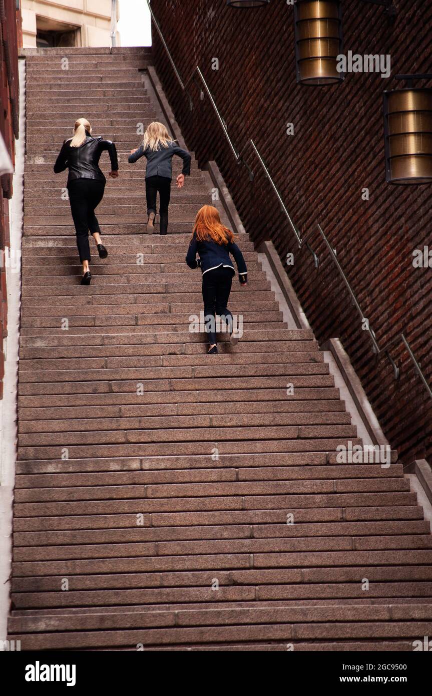 Three girls running up the stairs Stock Photo - Alamy
