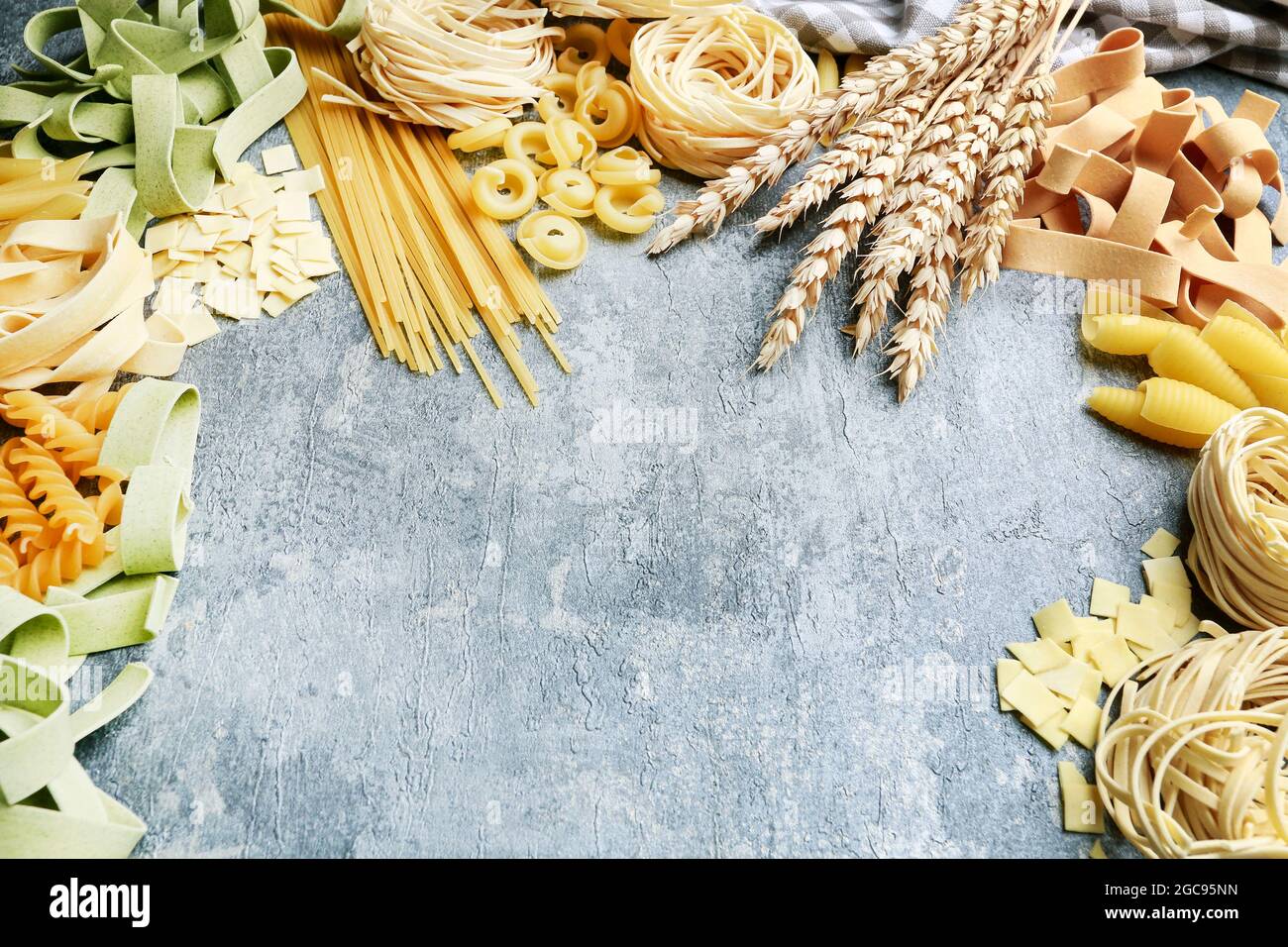 Mixed types and shapes of italian pasta on grey stone, background. Copy ...