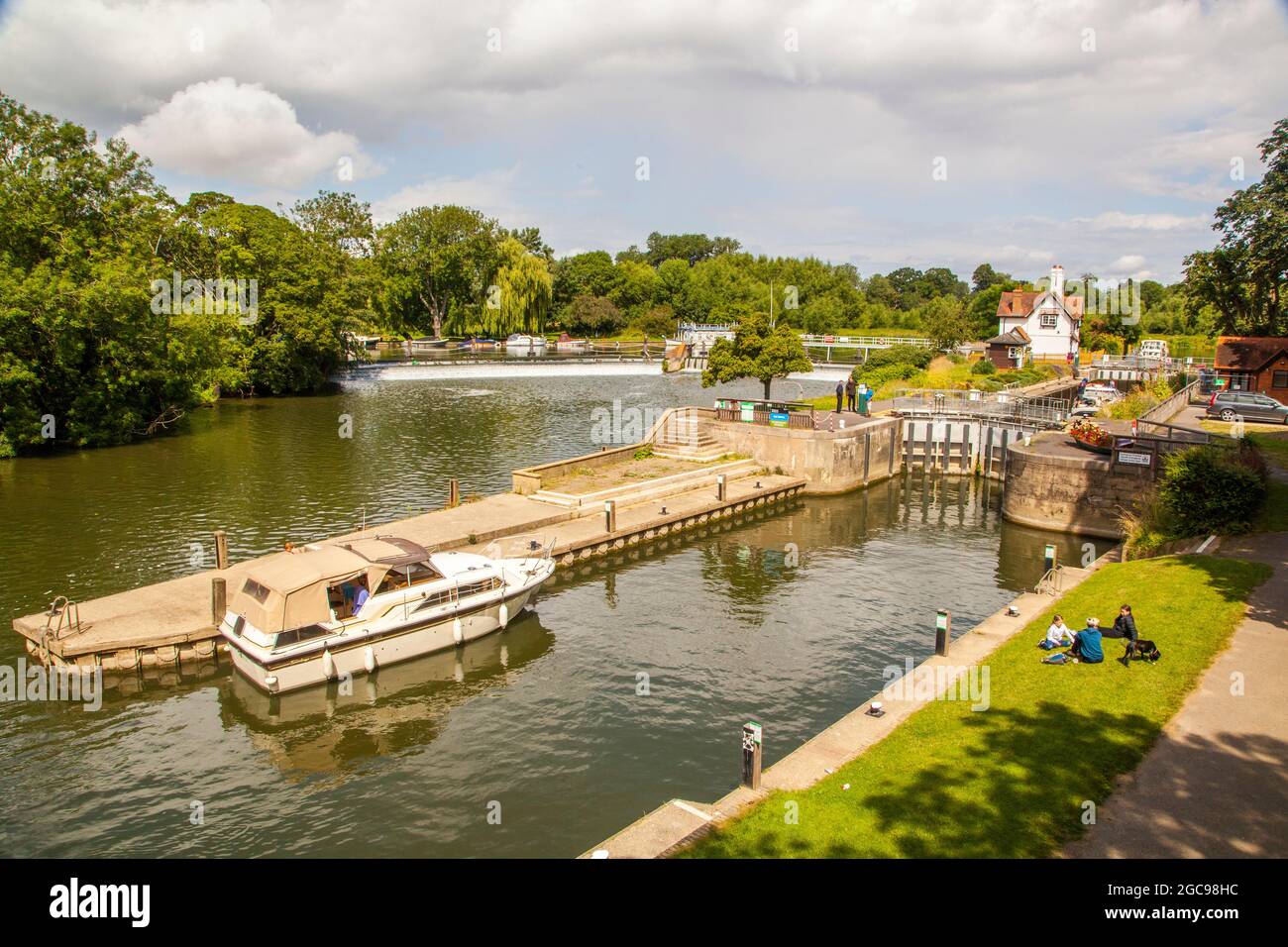 Canal narrow boat and people in rowing boats passing through the locks ...