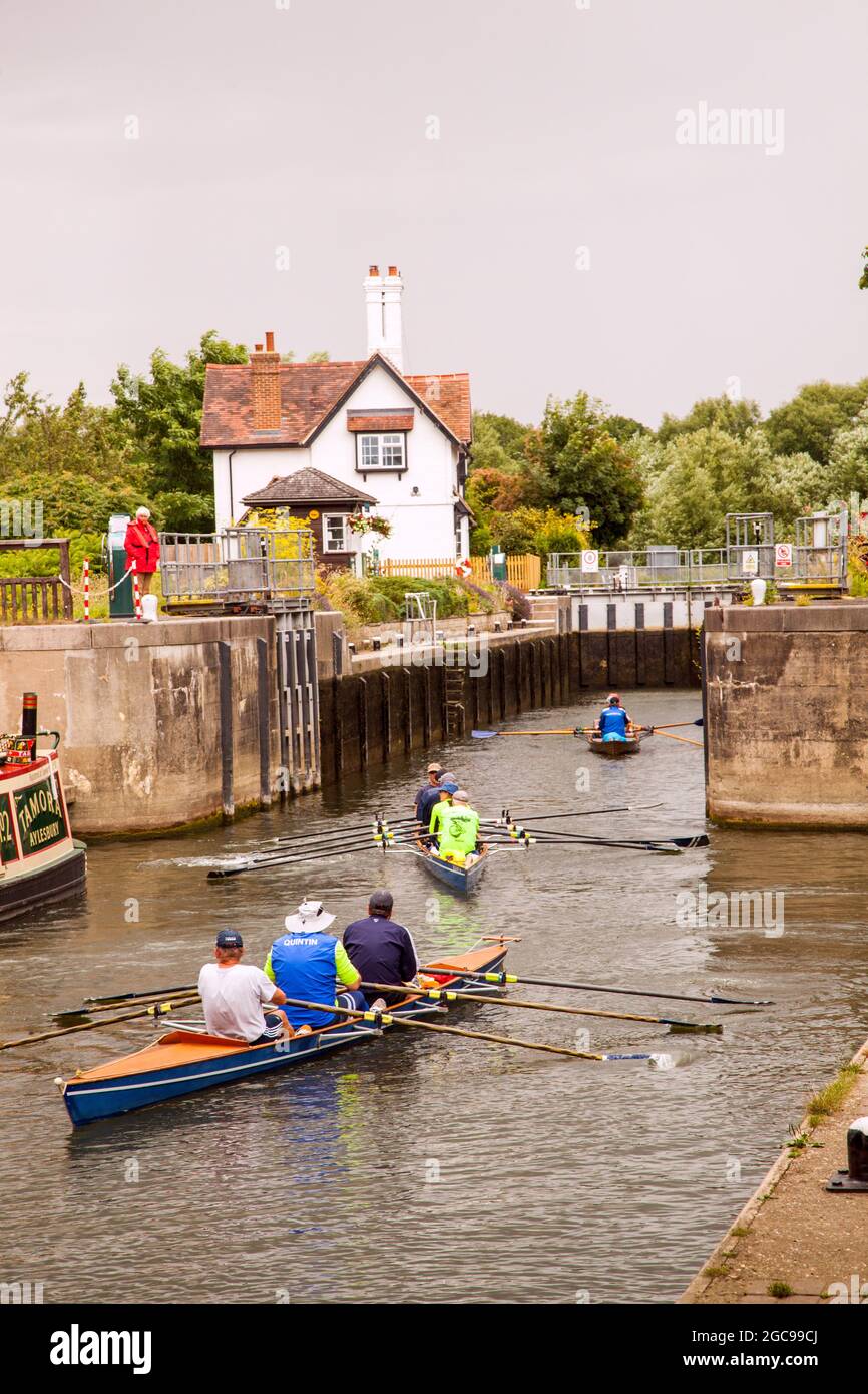 People in rowing boats rowing along the river Thames at Goring on ...