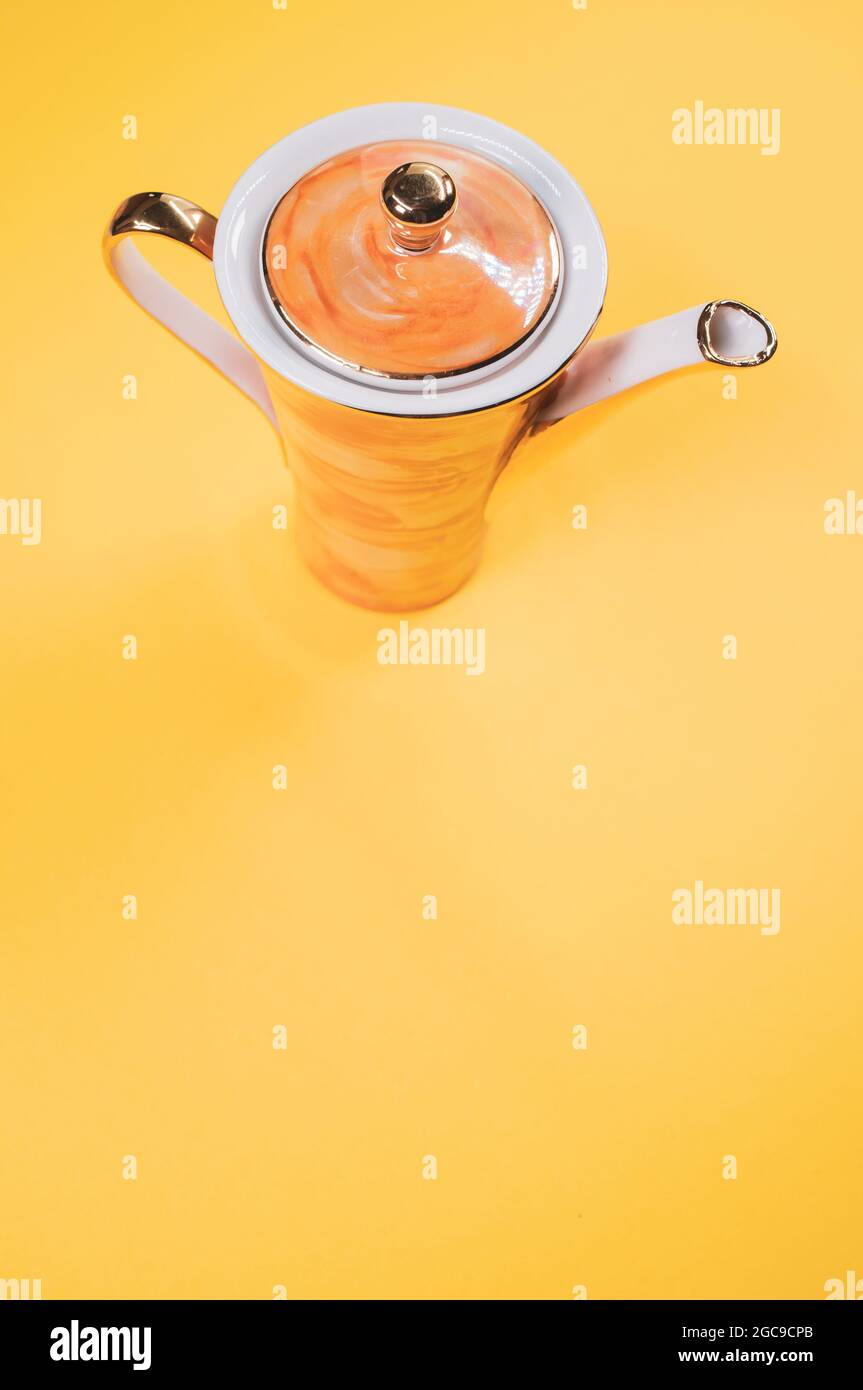 Close up of a slim orange covered teapot on an orange isolated ...