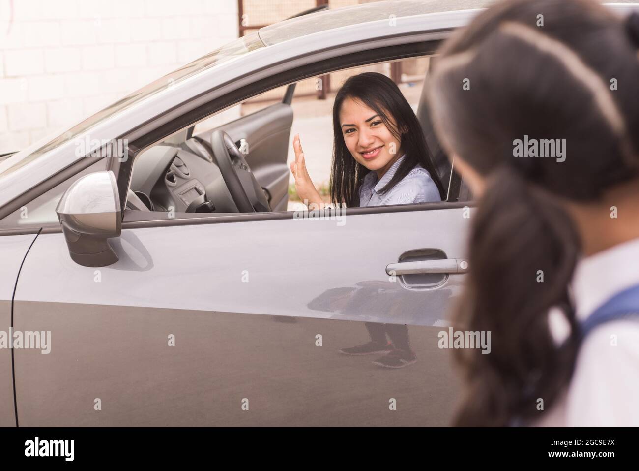 Young mother in the car waving her daughter goodbye Stock Photo - Alamy
