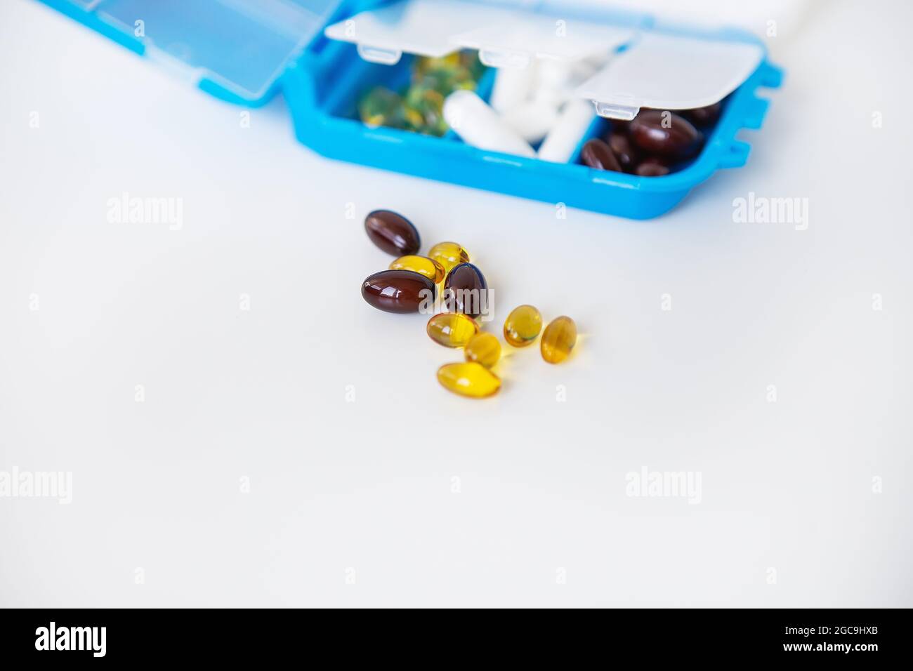 Pouring pills and capsules on a white background close-up. Top view ...