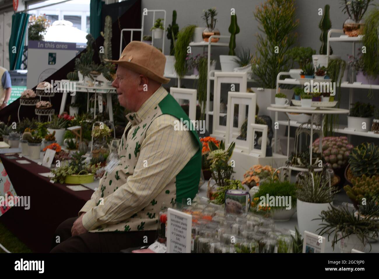 stallholder in hat with plants Stock Photo - Alamy