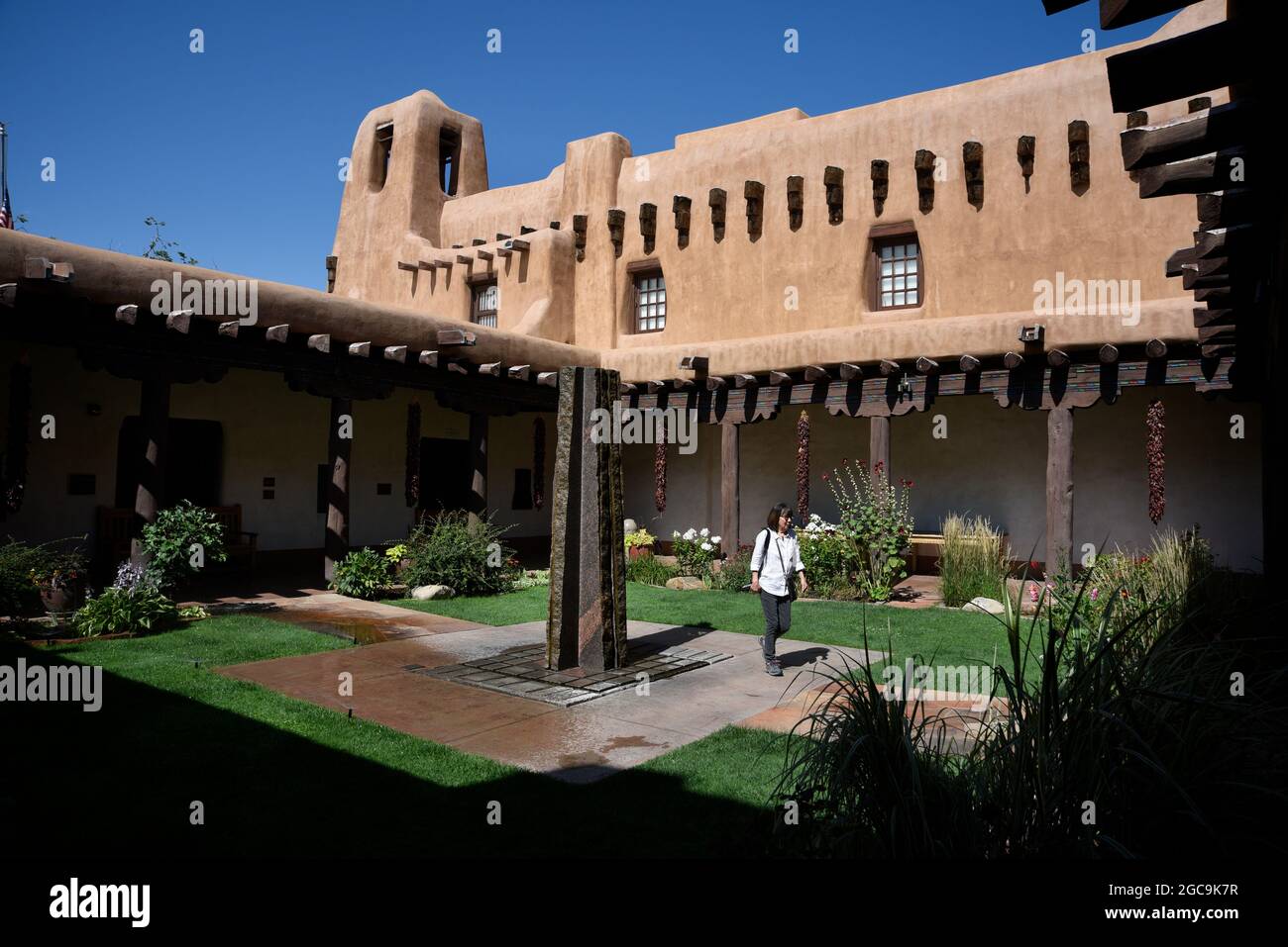 A museum visitor walks in the courtyard at the New Mexico Museum of Art ...