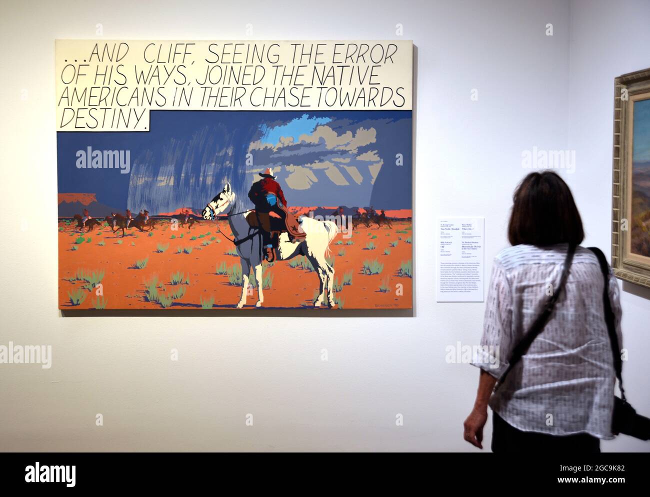 A museum visitor admires a painting y American western pop artist Billy ...