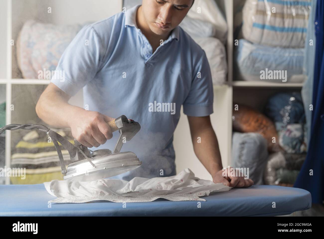 Laundry male worker steam ironing a shirt Stock Photo - Alamy