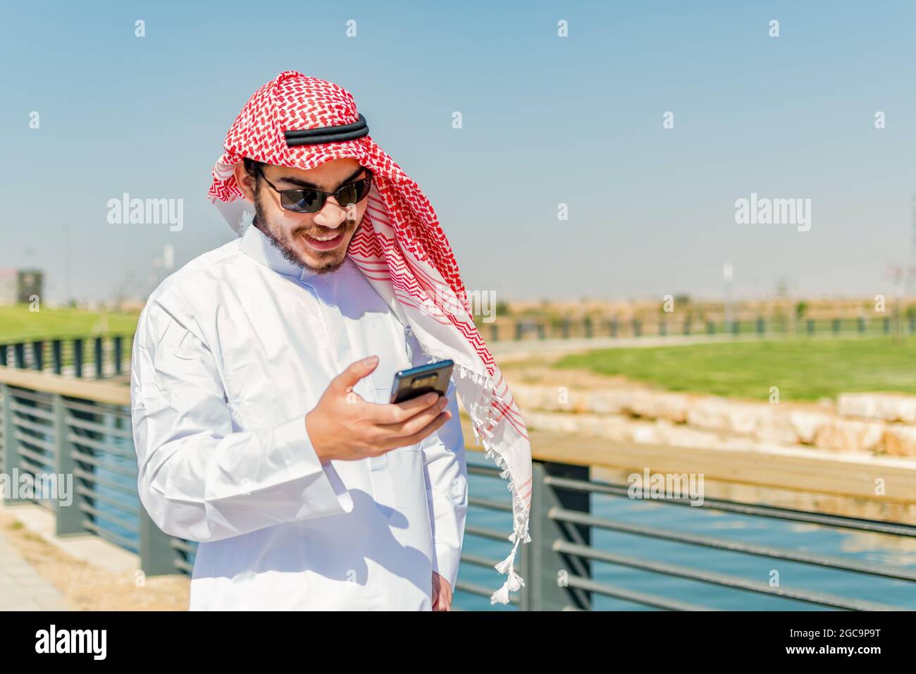 Arab saudi male using a smart phone outdoor in a park Stock Photo - Alamy