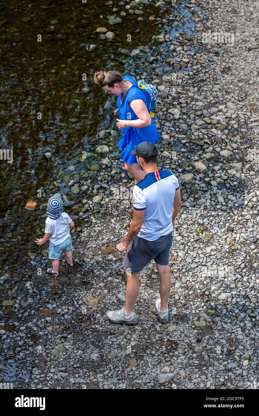 young family playing in river, playing together, parents with child at ...