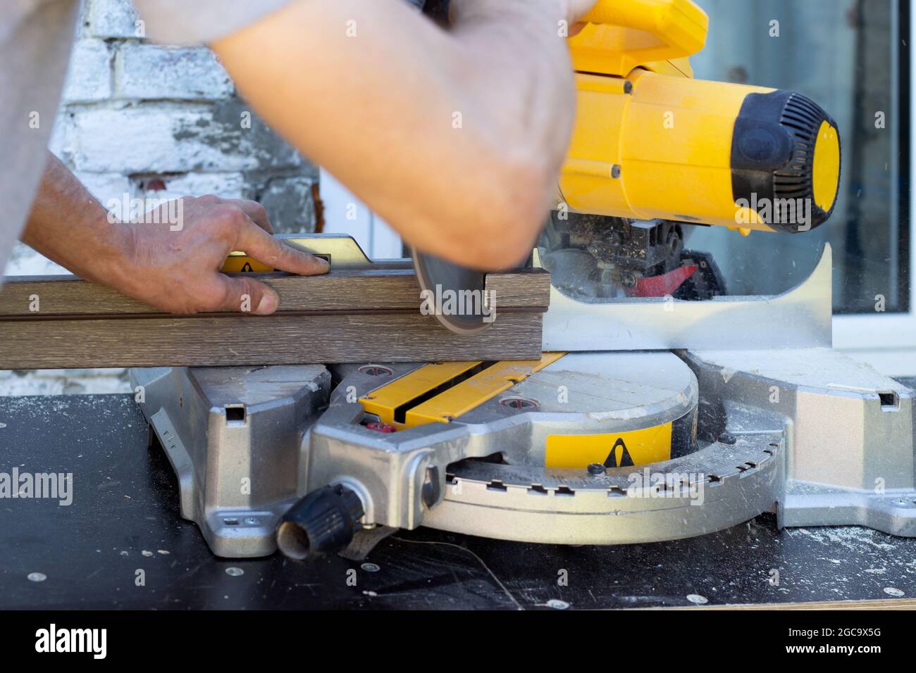 The craftsman sawed a wooden board with a circular miter saw ...