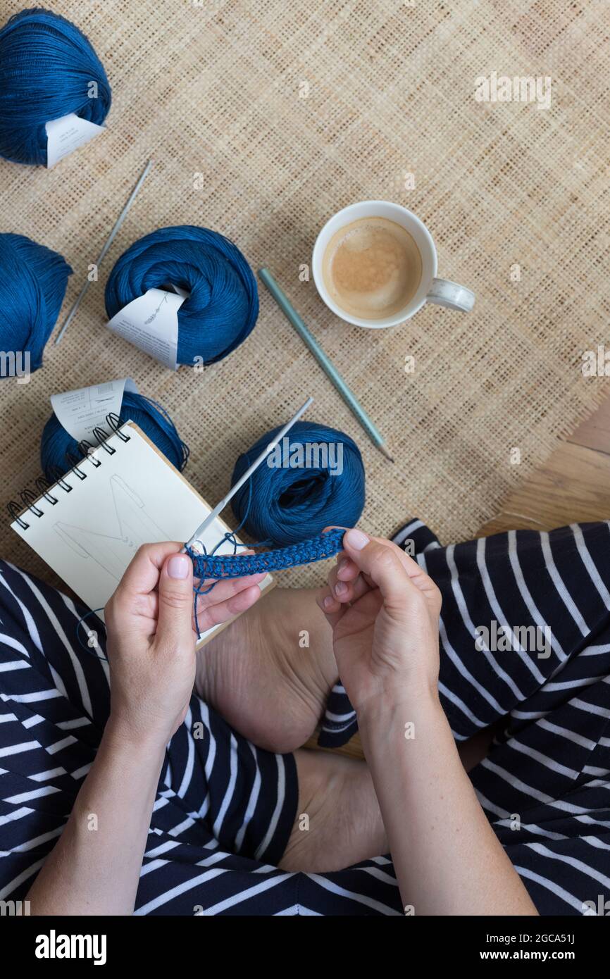 Overhead view of a leg crossed woman in striped dress doing chain ...