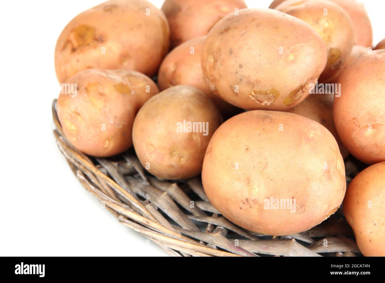 Potato on wicker wooden tray isolated on white Stock Photo - Alamy