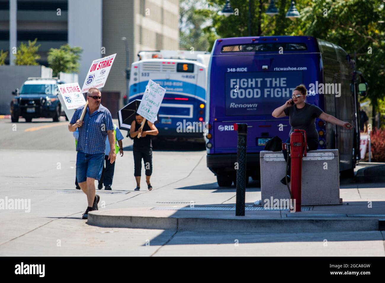 Reno, Nevada, USA. 3rd Aug, 2021. Protesters hold picket signs at a bus ...