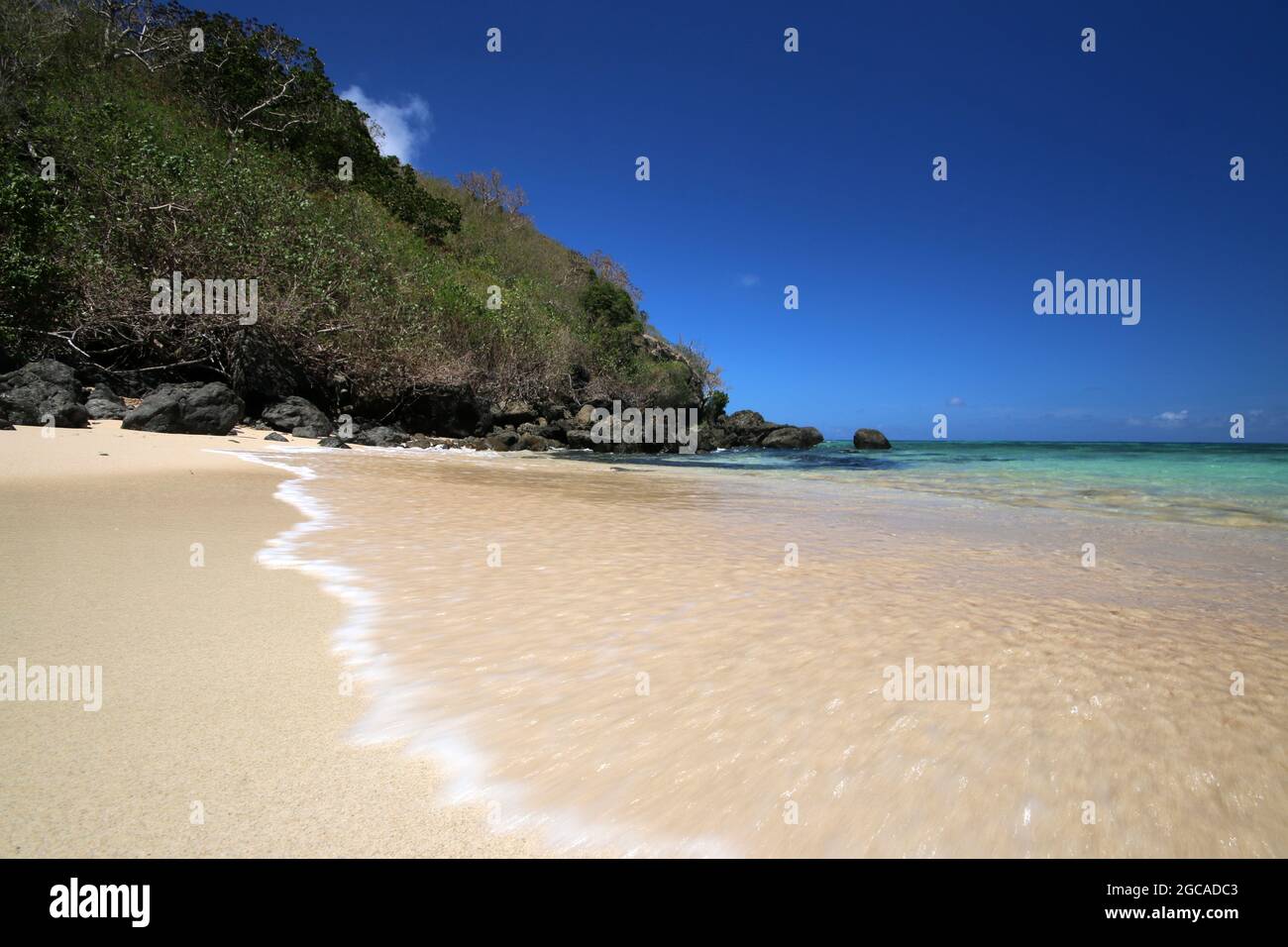 a sandy beach next to a body of water Stock Photo - Alamy