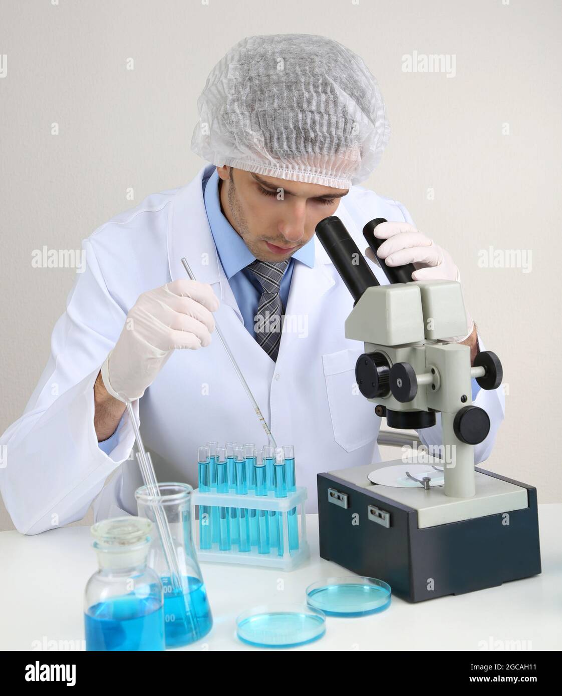 Young laboratory scientist looking at microscope in lab Stock Photo - Alamy