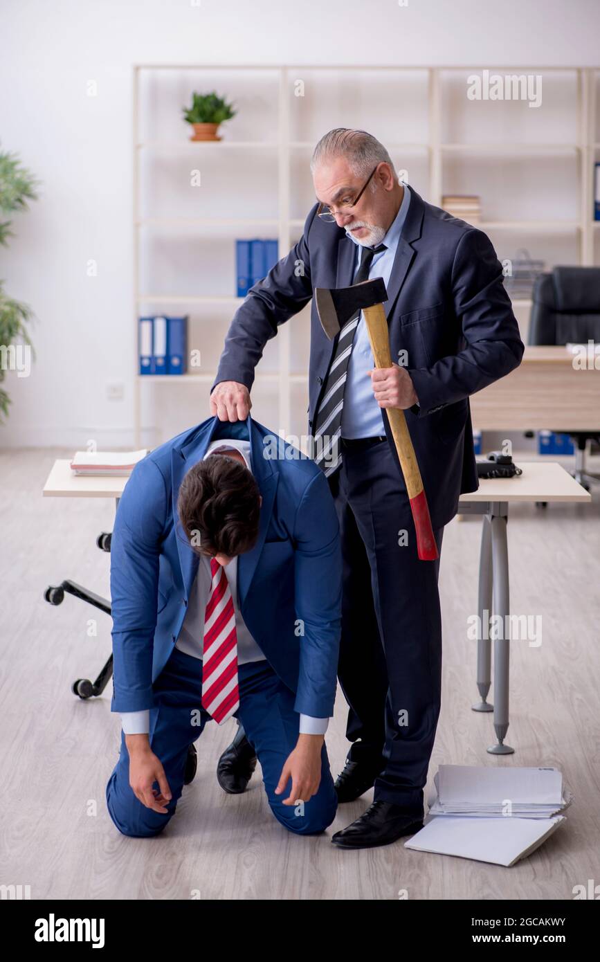 Old boss and young employee in bullying concept Stock Photo - Alamy