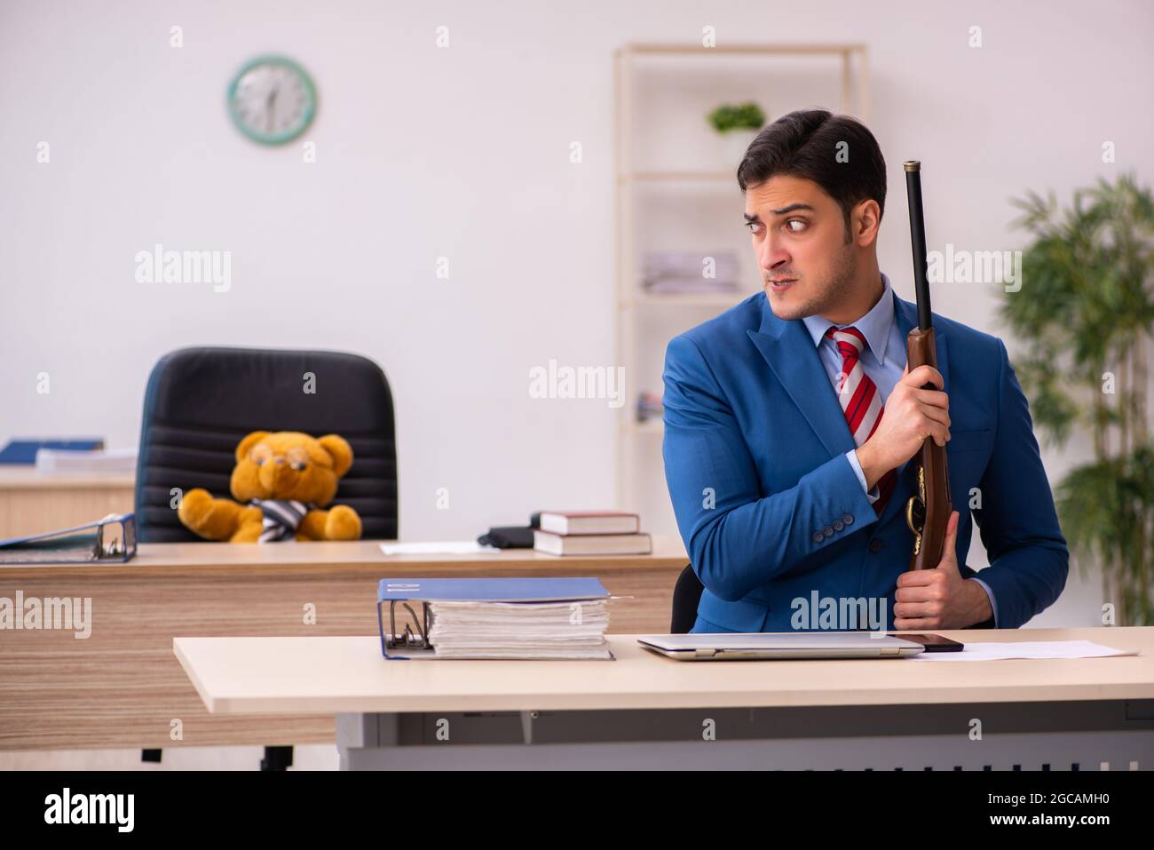 Young employee and his toy bear boss in funny concept Stock Photo - Alamy