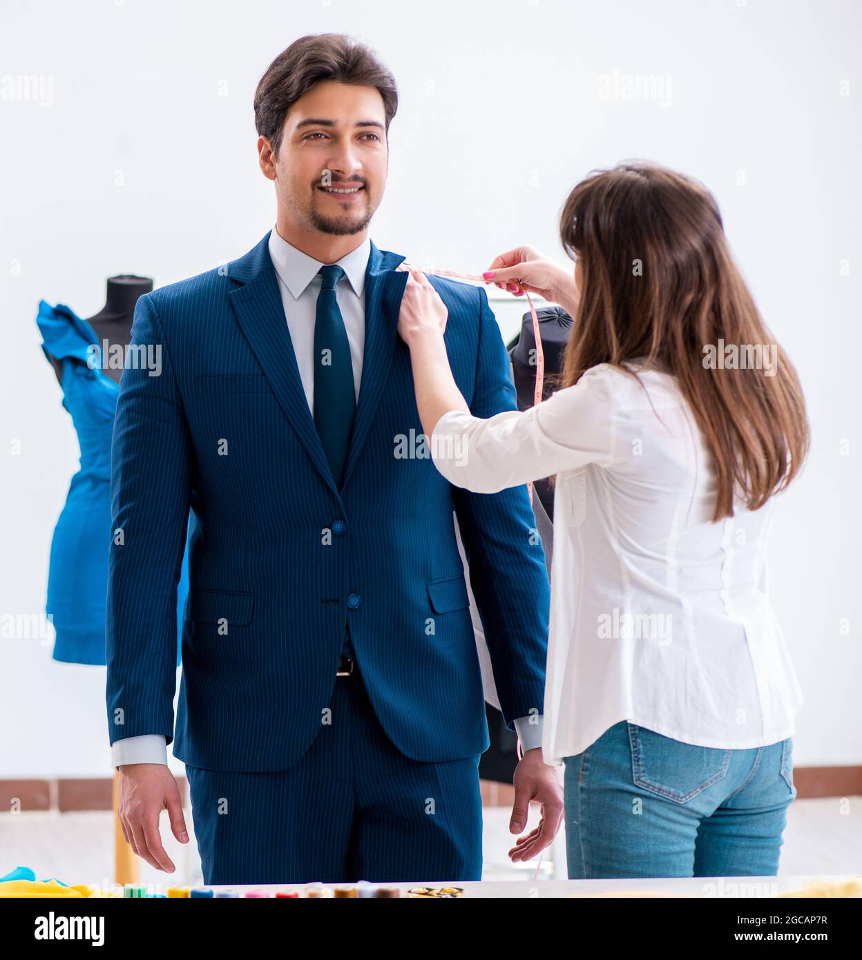 The professional tailor taking measurements for formal suit Stock Photo ...