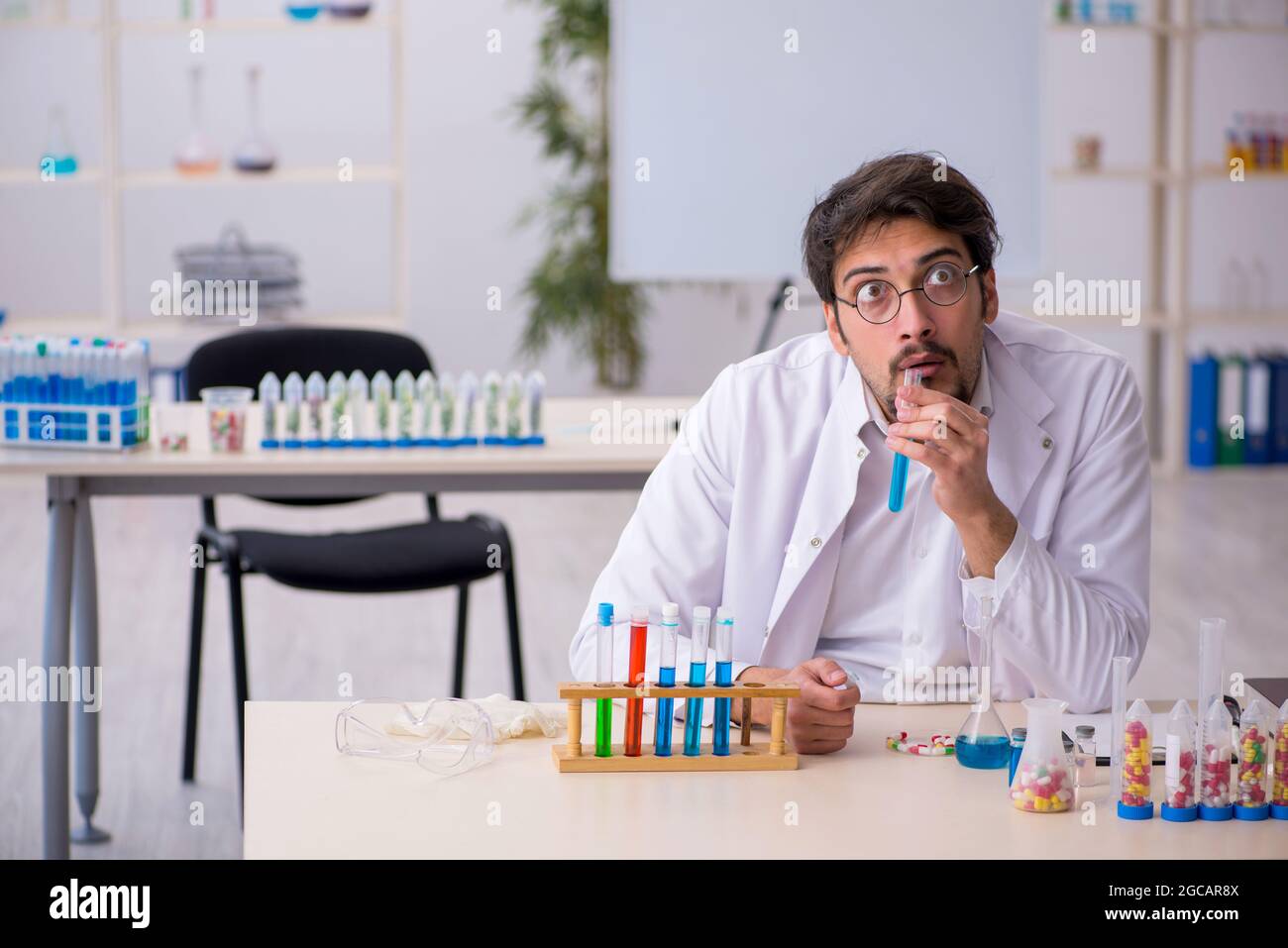 Young chemist in drugs synthesis concept Stock Photo - Alamy