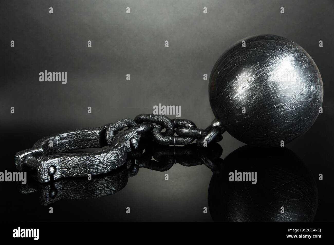 Ball and chain on grey background Stock Photo - Alamy
