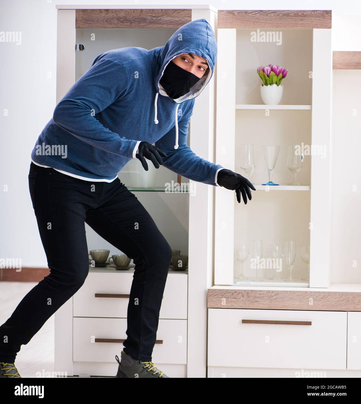 The man burglar stealing tv set from house Stock Photo - Alamy