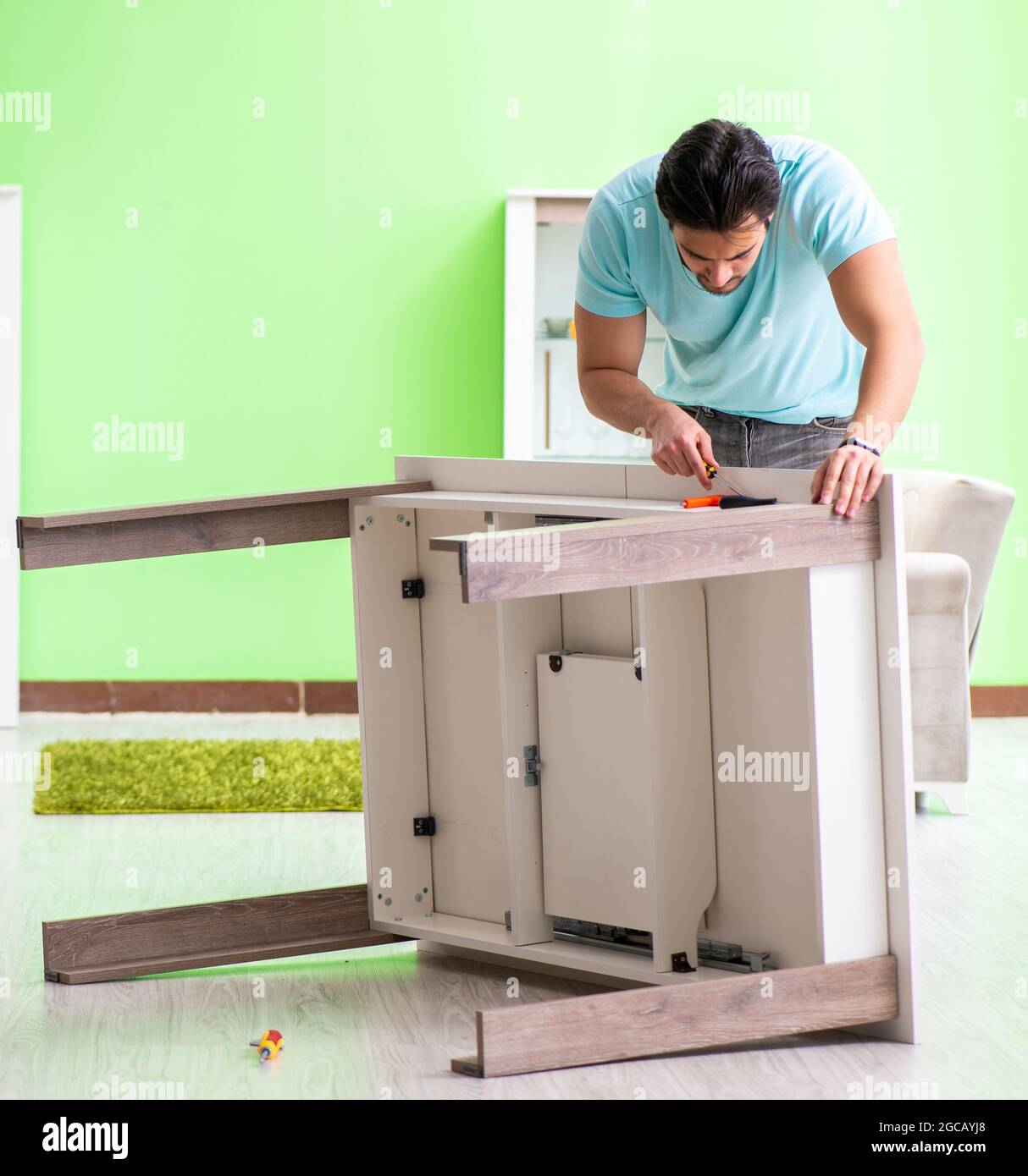 The man repairing furniture at home Stock Photo - Alamy