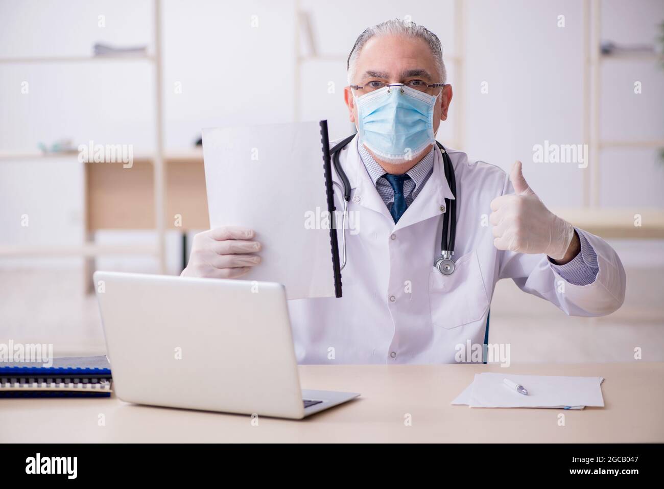 Old doctor working in the clinic Stock Photo - Alamy