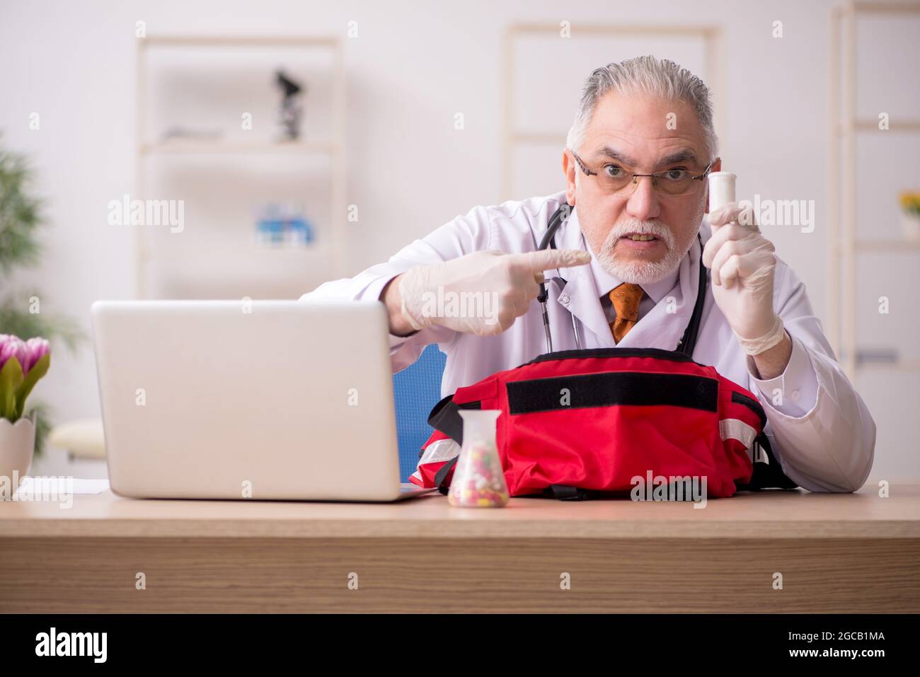 Old doctor in first aid concept Stock Photo - Alamy