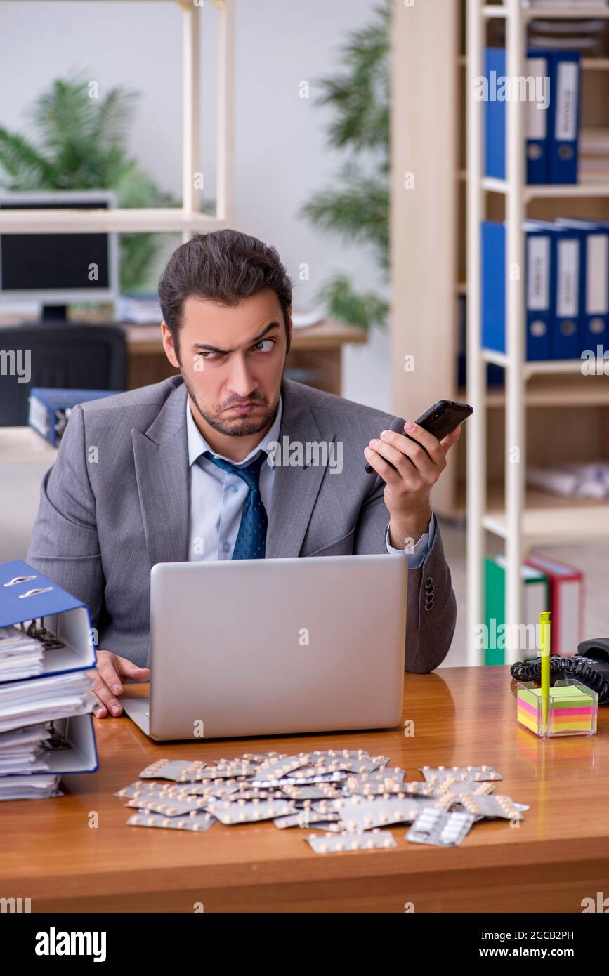 Male sick employee suffering at workplace Stock Photo - Alamy