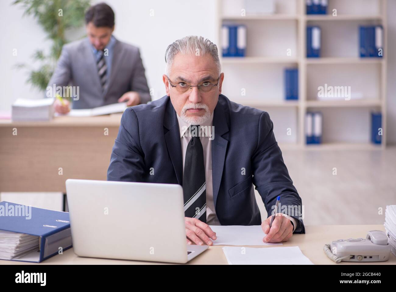 Two male employees working at workplace Stock Photo - Alamy