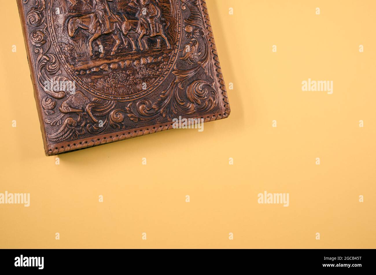 A brown leather wallet isolated on a yellow background with free space ...