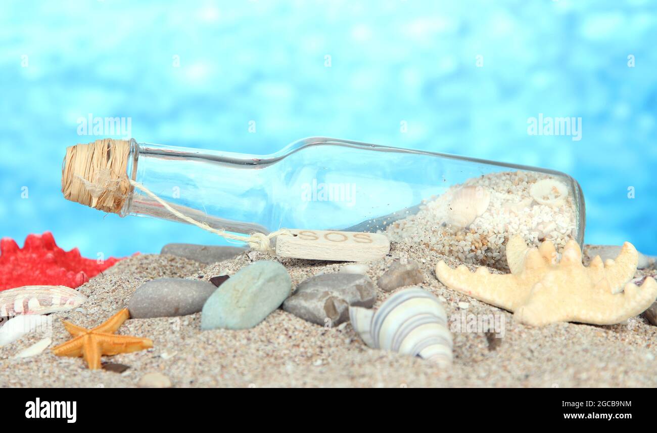Glass of bottle with note inside on bright blue background Stock Photo ...