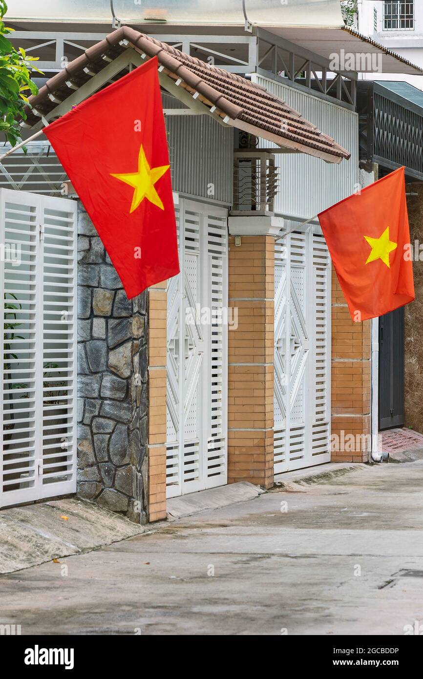 Tet holiday - national flag hung in front of houses in a street in the ...