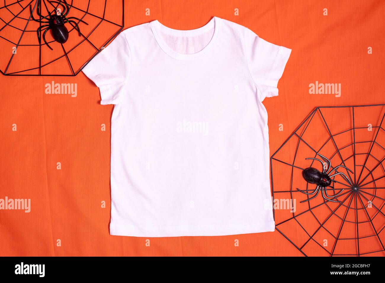 White t-shirt mockup on orange halloween background Stock Photo - Alamy