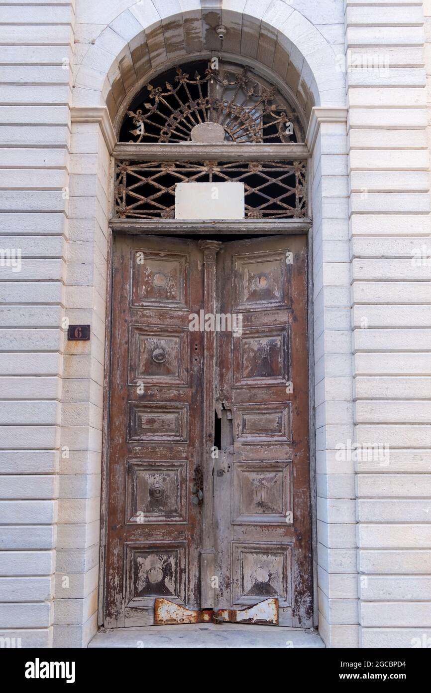 Door half opened ornamental wooden brown with rusty metallic arch ...