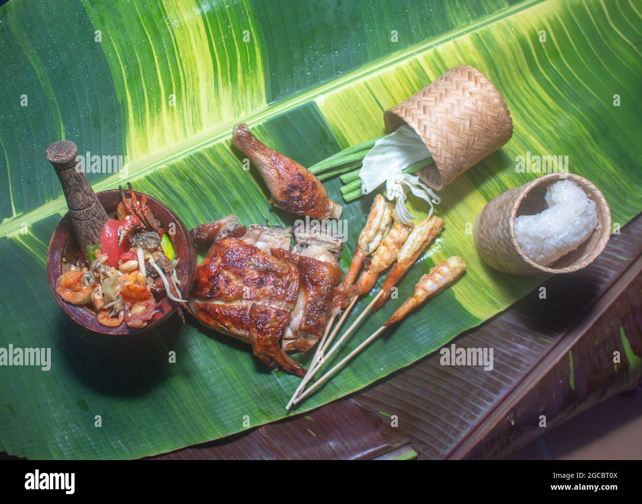 Sticky rice, papaya salad, grilled chicken and grilled shrimp served on ...