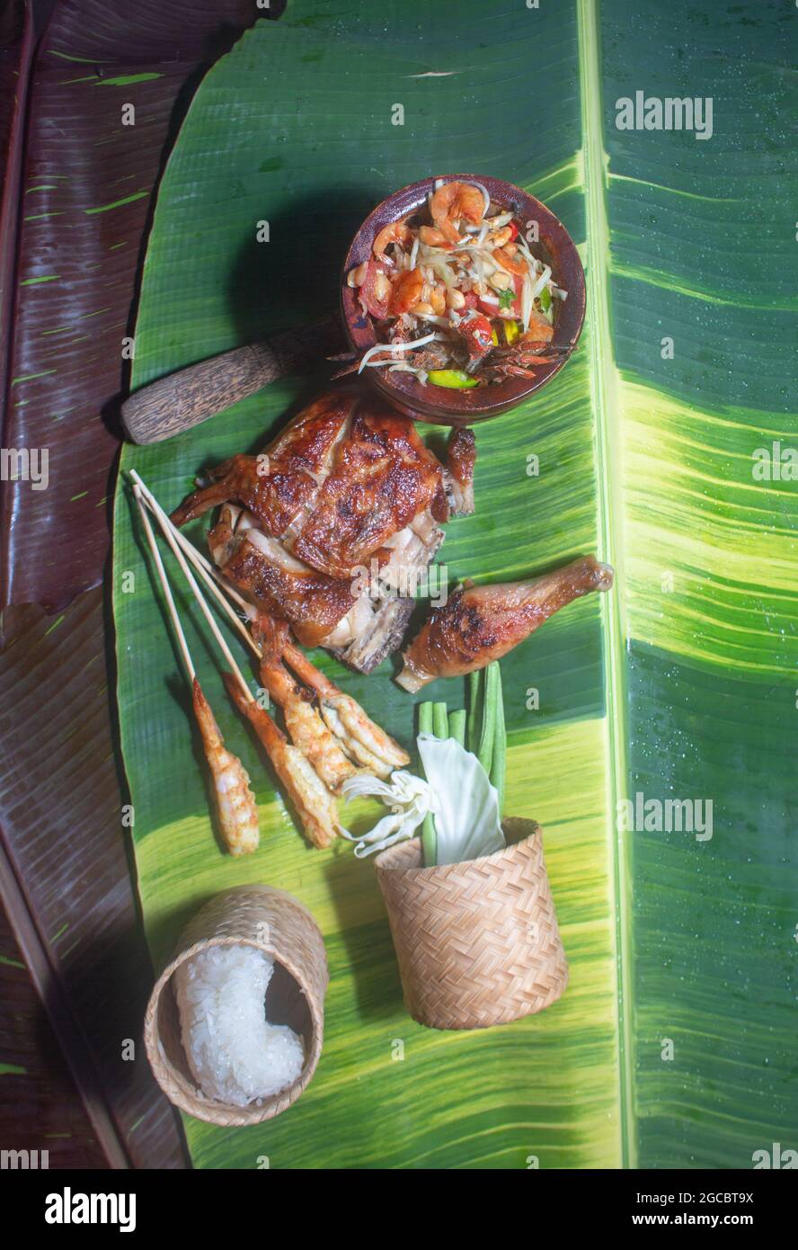 Sticky rice, papaya salad, grilled chicken and grilled shrimp served on ...