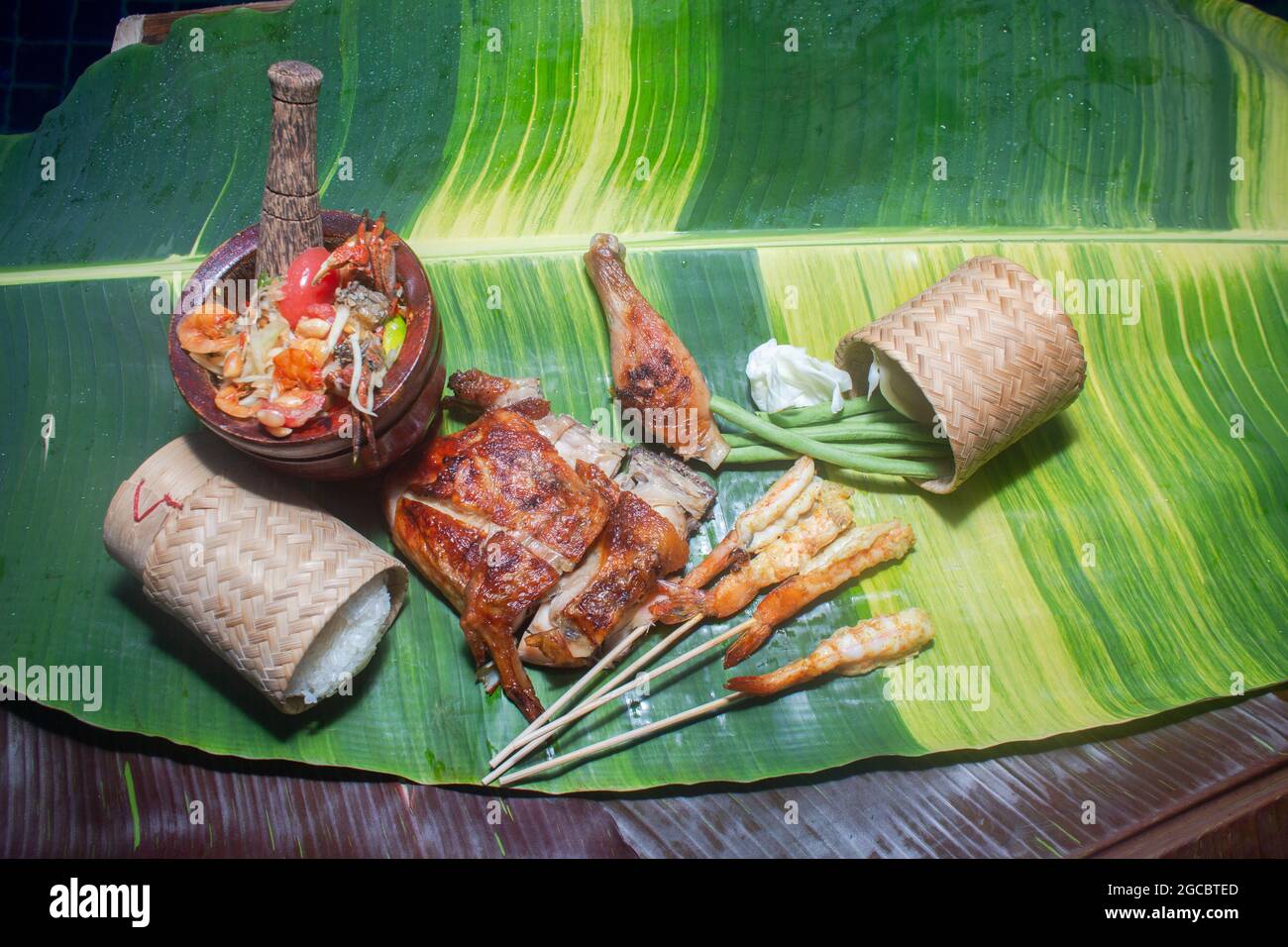 Sticky rice, papaya salad, grilled chicken and grilled shrimp served on ...