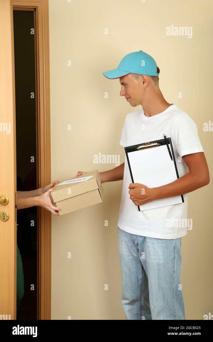 Young delivery man giving parcel Stock Photo - Alamy