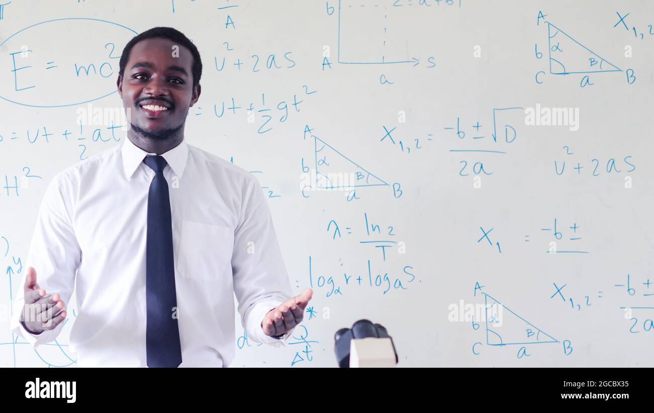 African scientist teacher is teaching science classes with using ...