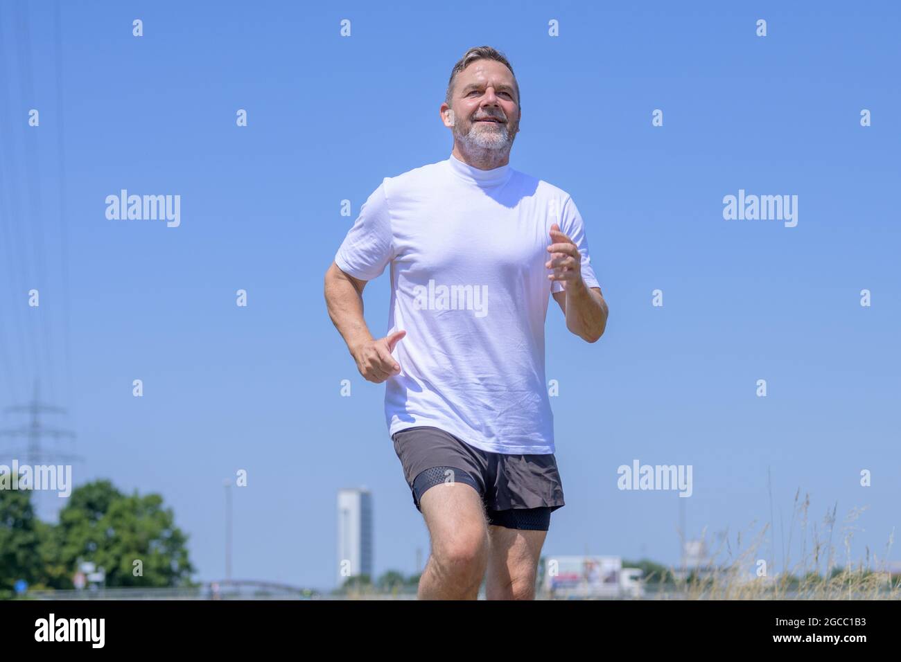 Low angle view of a senior man working out jogging against a clear ...