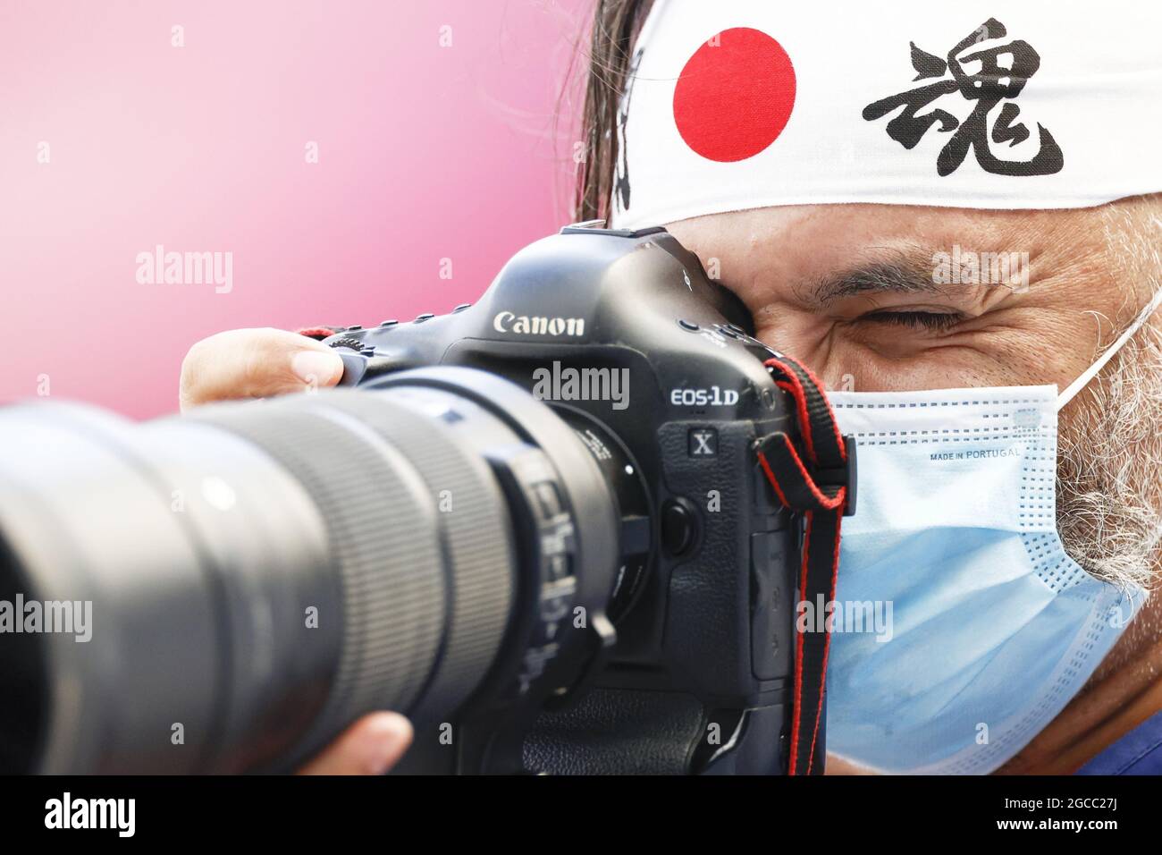 A photographer wearing a "hachimaki" reading fighting spirit in ...